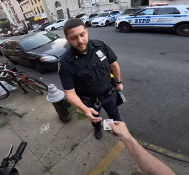 Ciclista multado por confrontar policial com carro na calçada